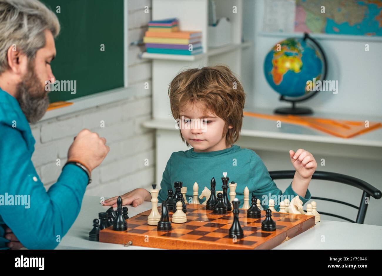 Boy with father teaching and learning chess at home. Teacher and kid ...
