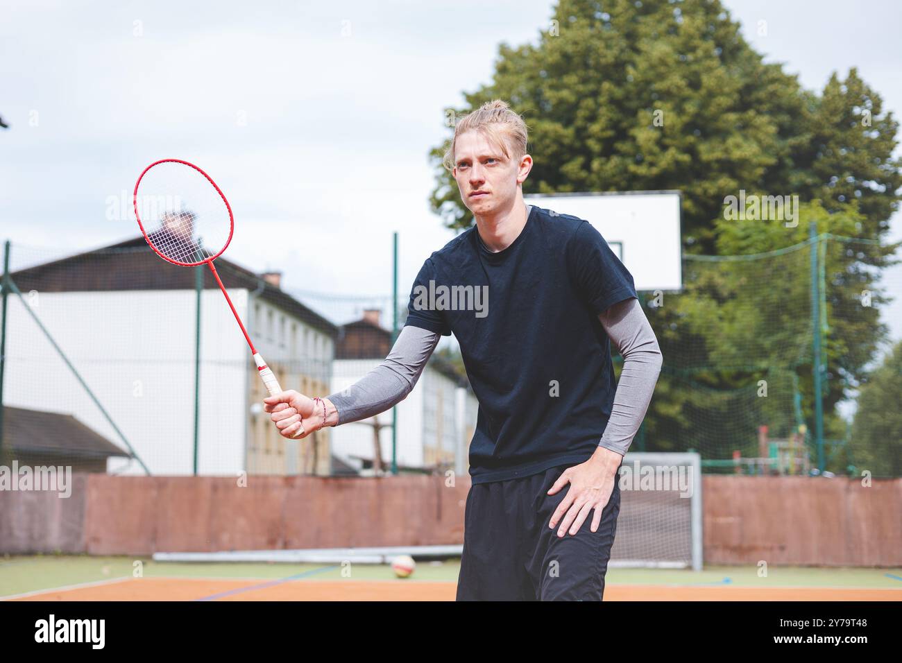 Badminton player strikes the shuttlecock during a game on an outdoor ...
