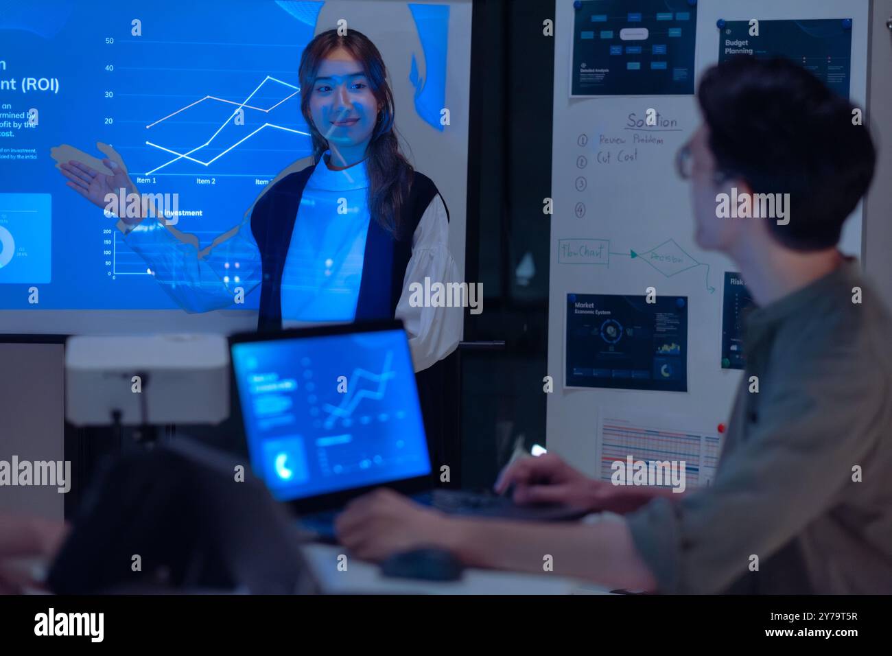 asian leader present business presentation in a dimly lit office ...