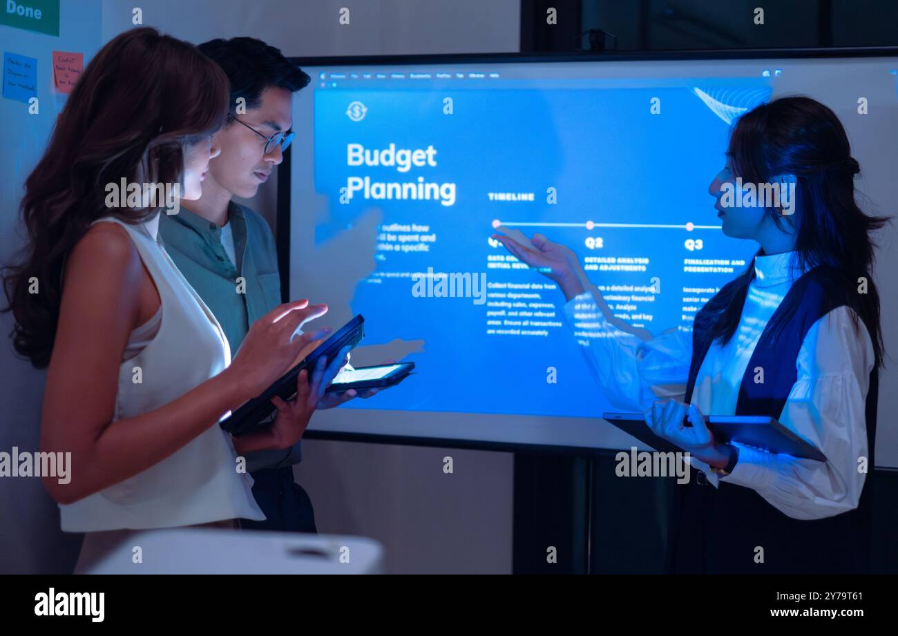 asian leader present business presentation in a dimly lit office ...