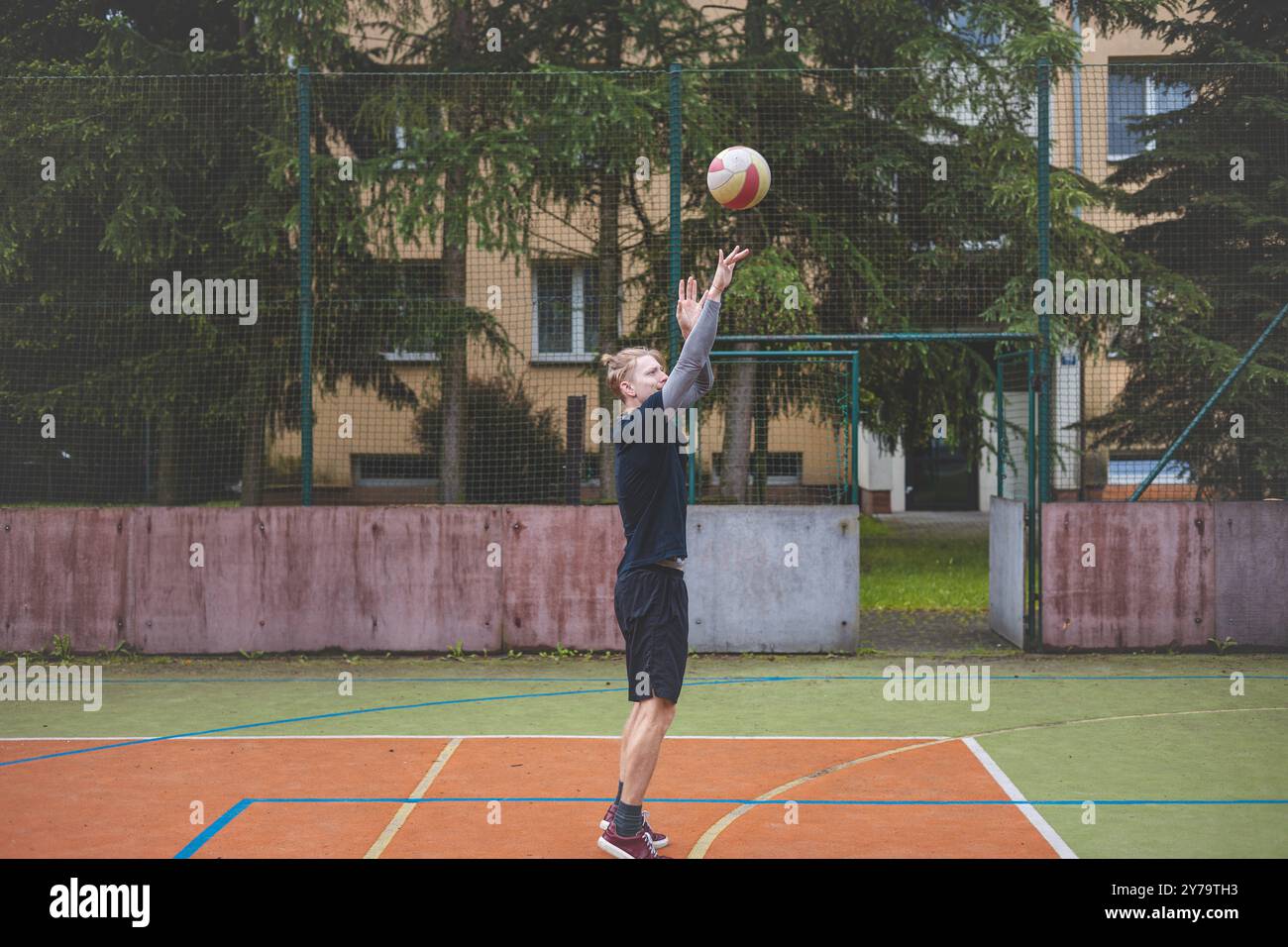 Basketball player prepares to shoot the ball on an outdoor court ...