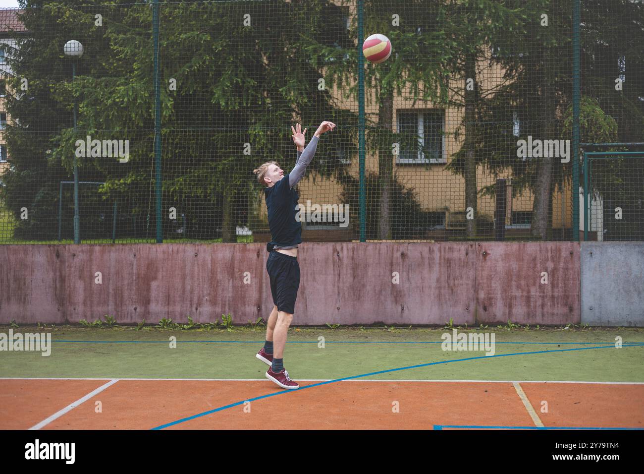 Basketball player prepares to shoot the ball on an outdoor court ...