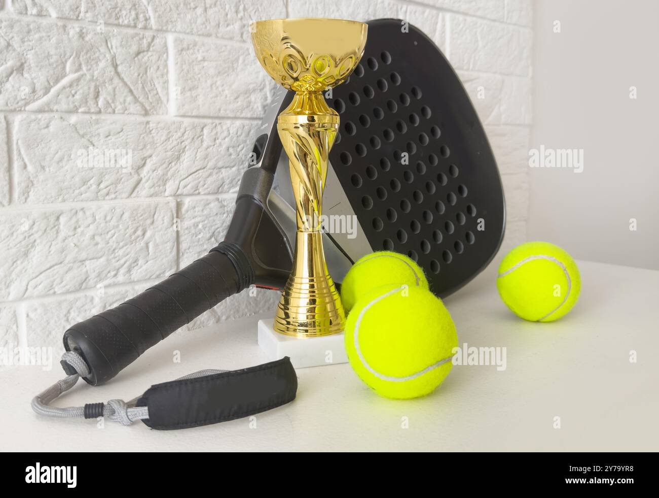 Golden trophy and padel racket. sport achievement, success concept ...