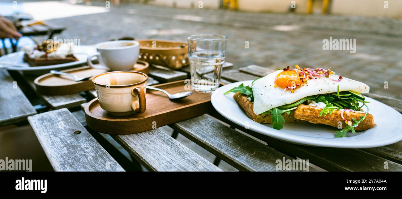 Coffe cup waffle with egg and rocket sandwich breakfast on outside ...