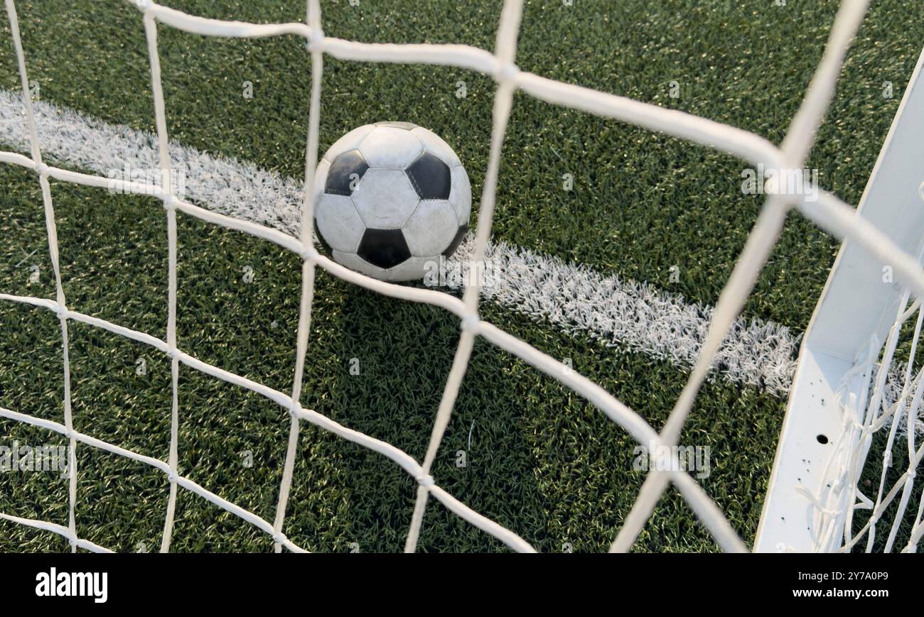 Soccer ball in goal on blue background Stock Photo - Alamy