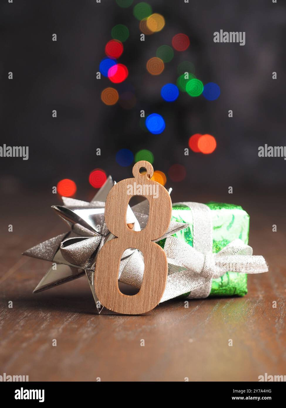 eighth December Wooden number one with pine cone on blurred Christmas ...