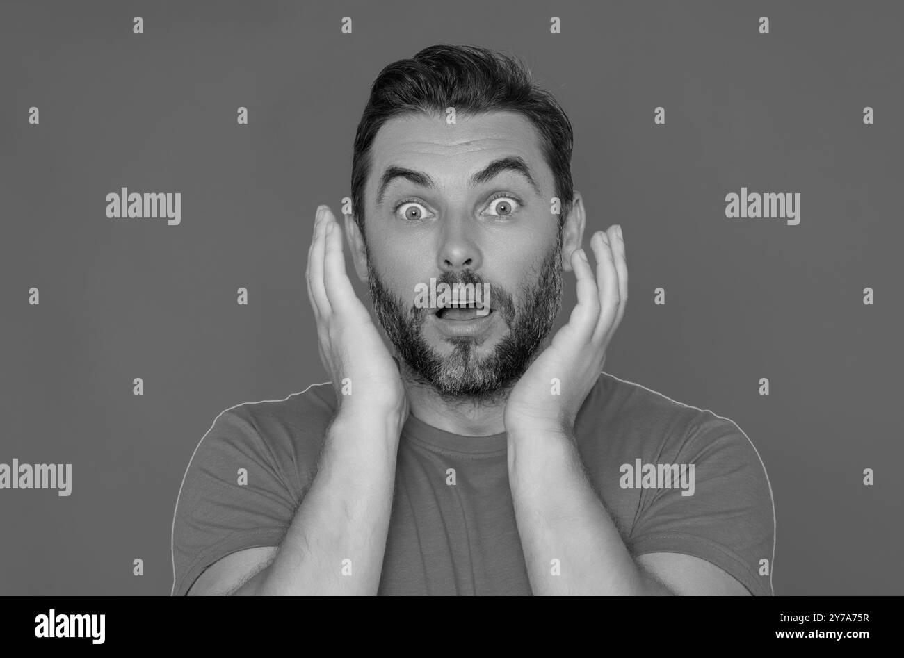 Studio portrait of a man shocked. Surprised man in blue t-shirt ...