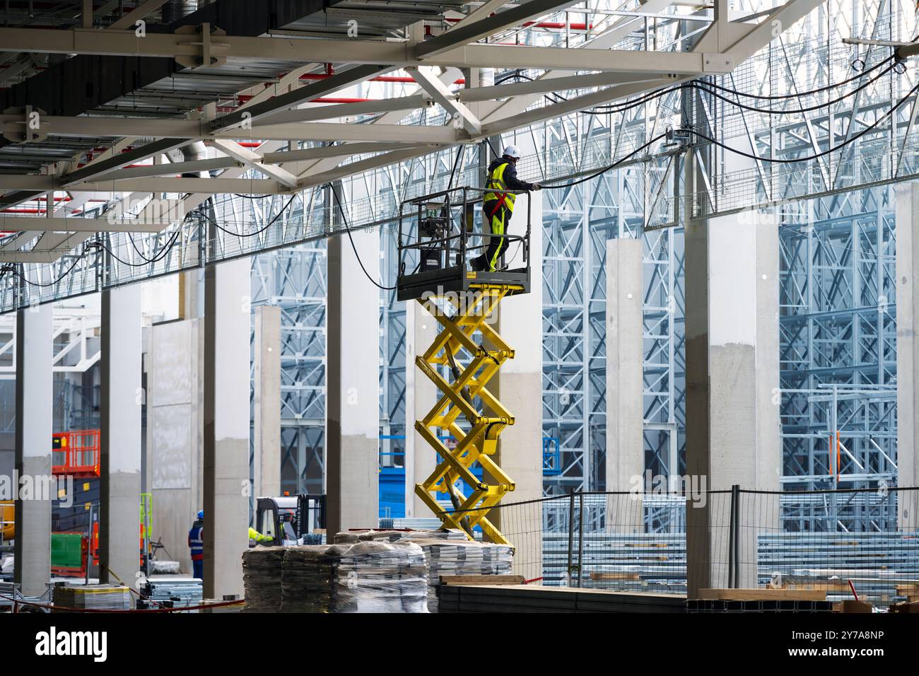 Electricians installing cables on cable trays working at height on ...