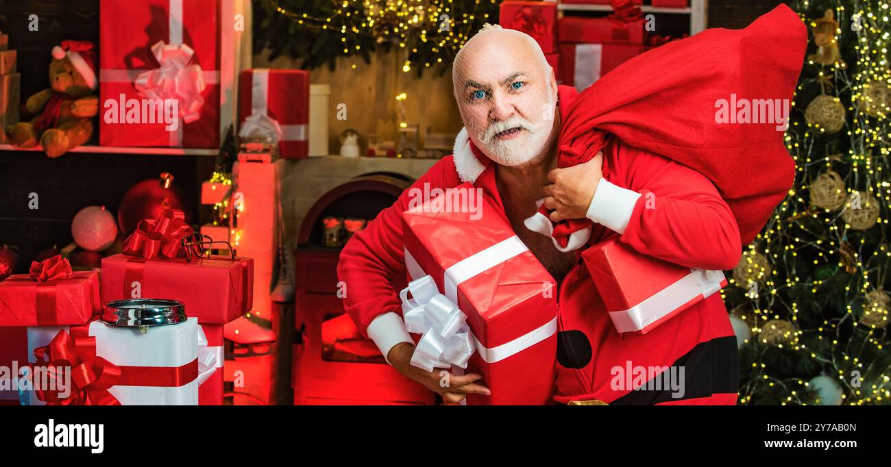 Criminal Santa posing with a steal bag of christmas gifts. Bad santa ...