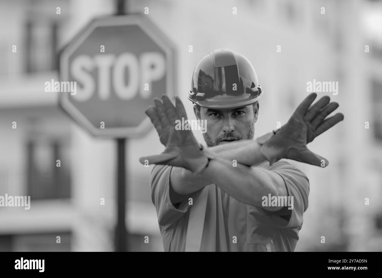 Worker builder with stop road sign. Man in hardhat helmet doing stop ...