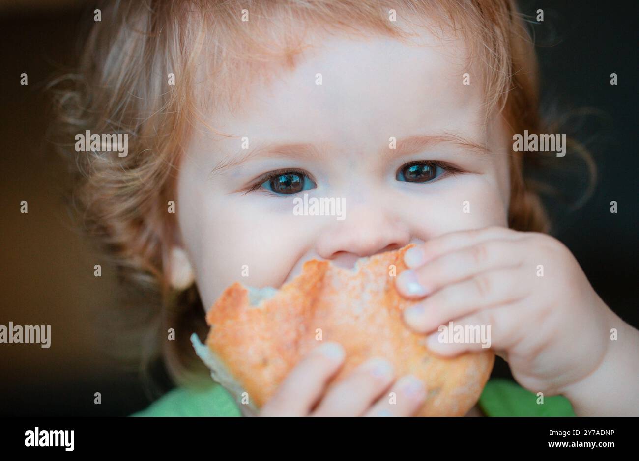 Baby eating bun bread. Close up face. Cute toddler child eating ...