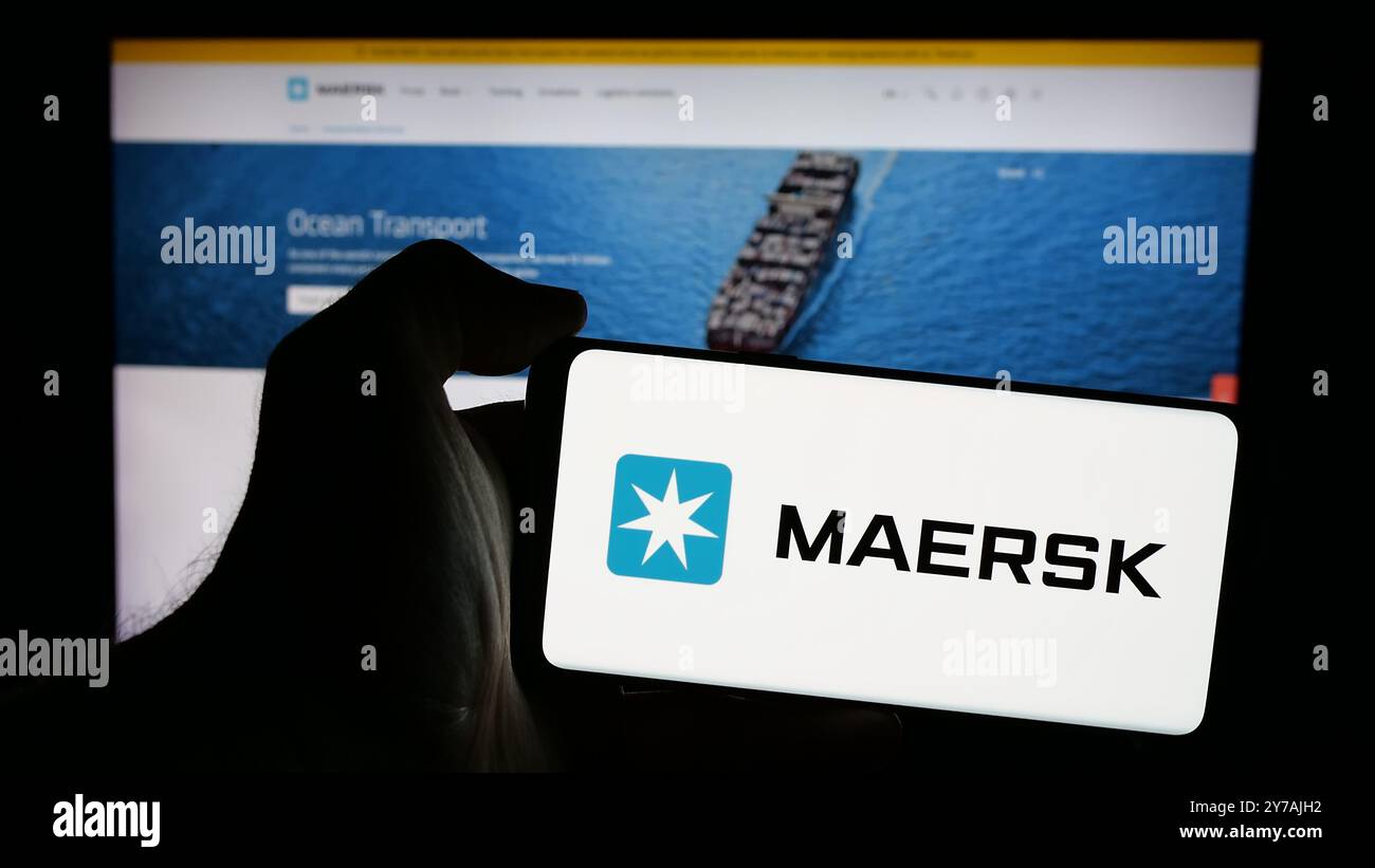 Person holding mobile phone with logo of Danish shipping company A.P ...