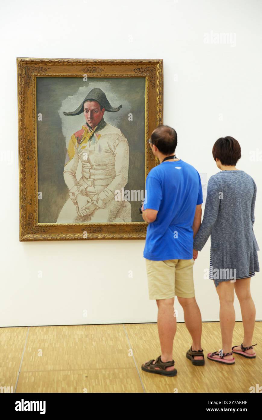 Couple looking at a painting, Arlequin, 1923. Pablo Picasso. Centre ...