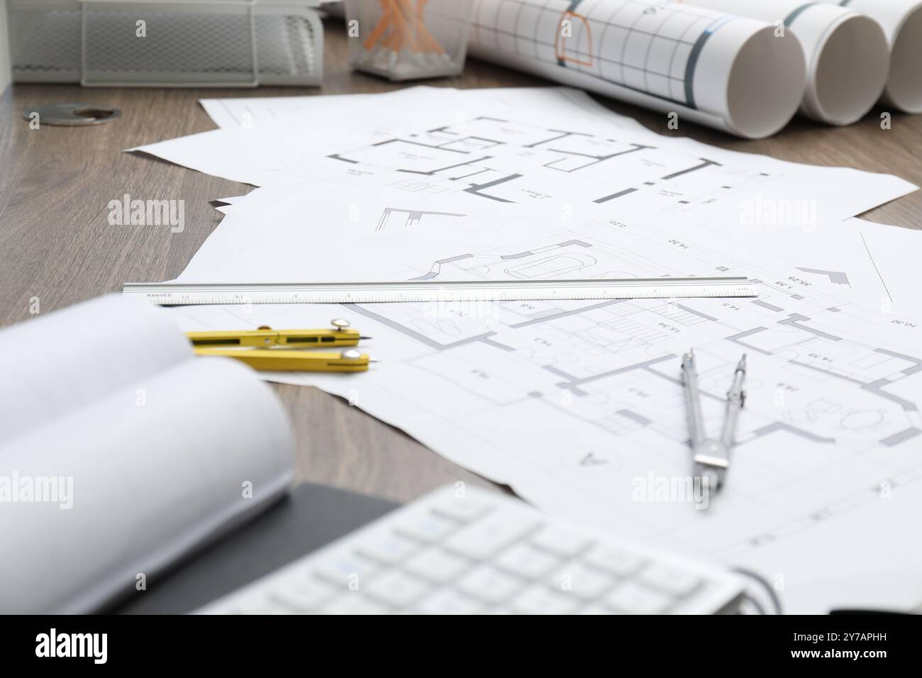 Different architectural drawings, dividers and ruler on wooden table ...
