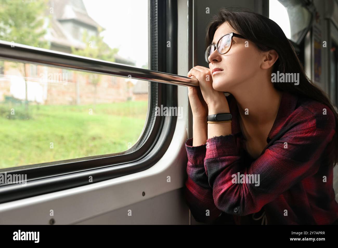 Beautiful woman looking out of train window during trip Stock Photo - Alamy