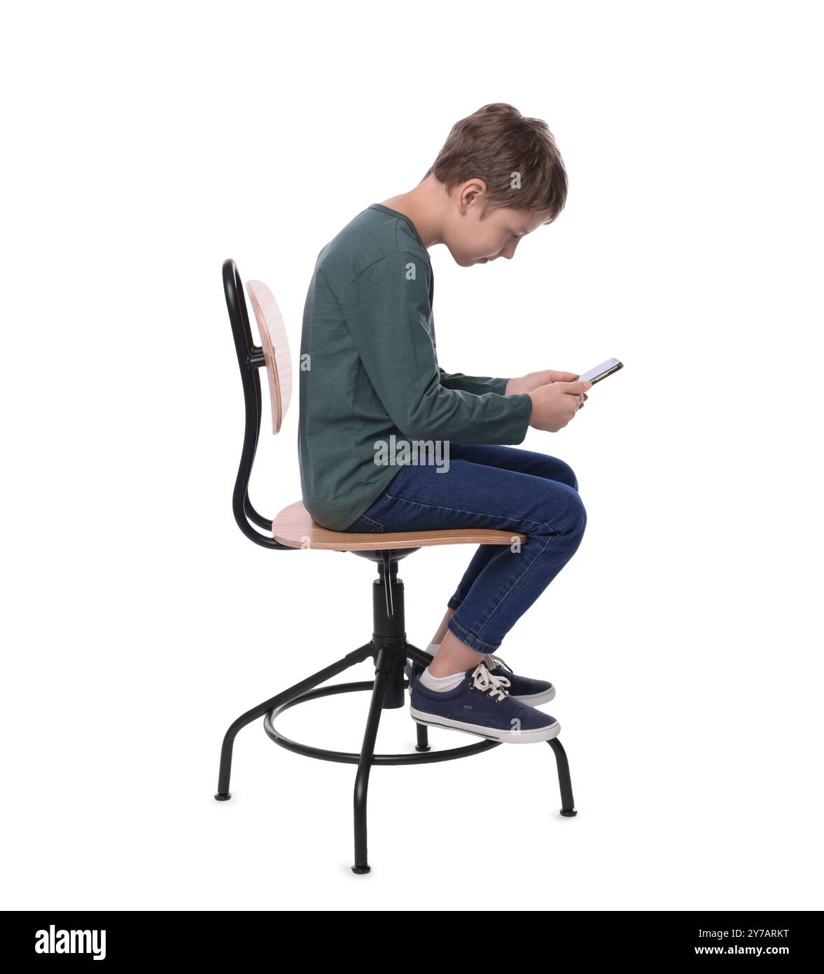 Boy with incorrect posture and phone sitting on chair against white ...