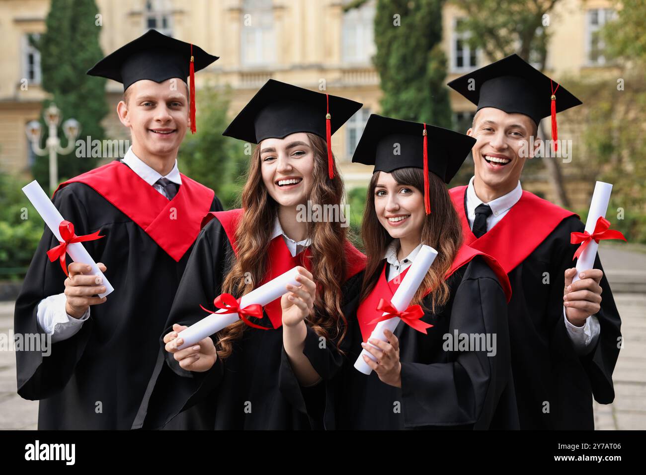 Happy students with diplomas after graduation ceremony outdoors Stock ...