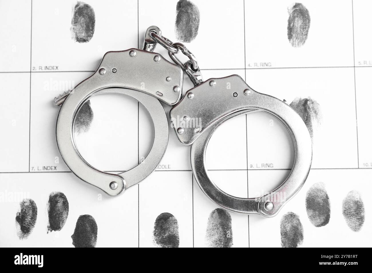 Human fingerprints and handcuffs on paper, top view. Criminal ...