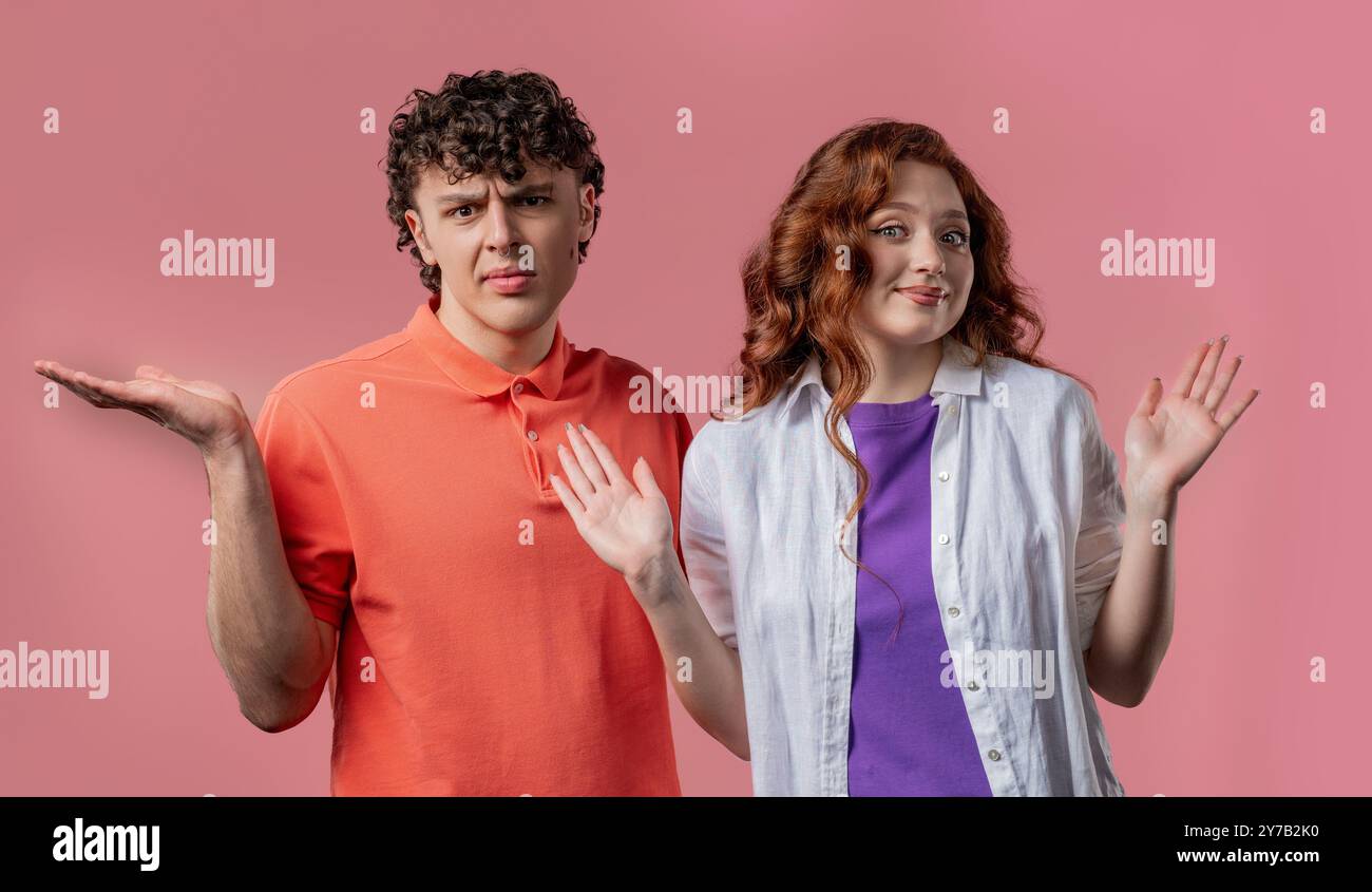Confused stylish couple shoulders up - can't help, makes gesture of ...