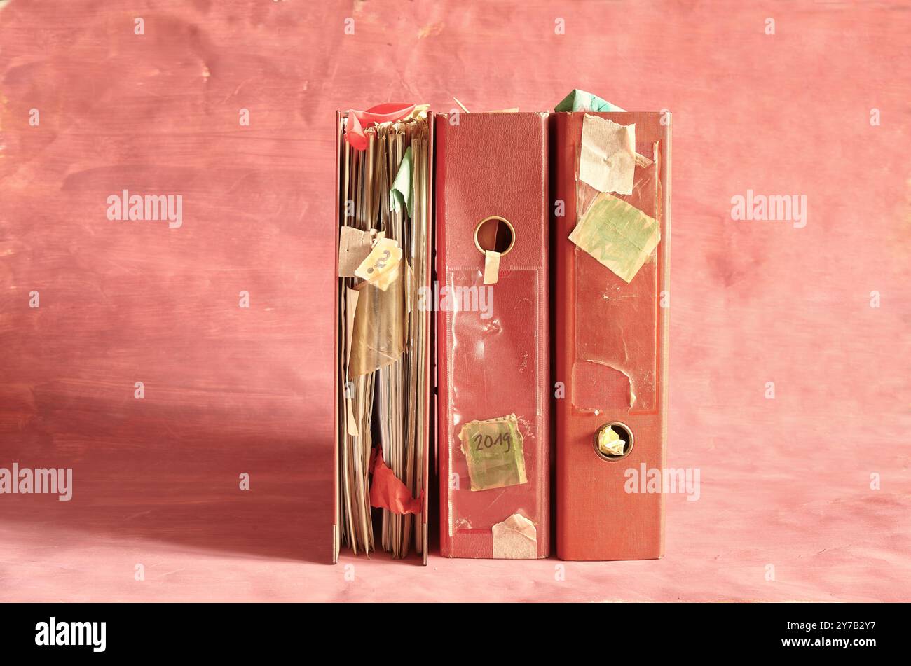 Row of messy file folders,grungy old business papers,red tape ...