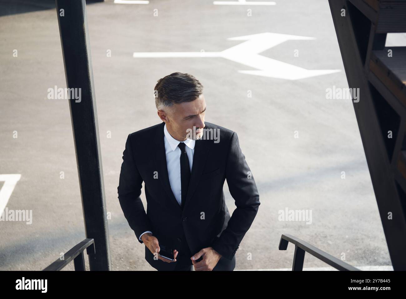 Top view of confident mature businessman carrying mobile phone while walking outdoors Stock ...