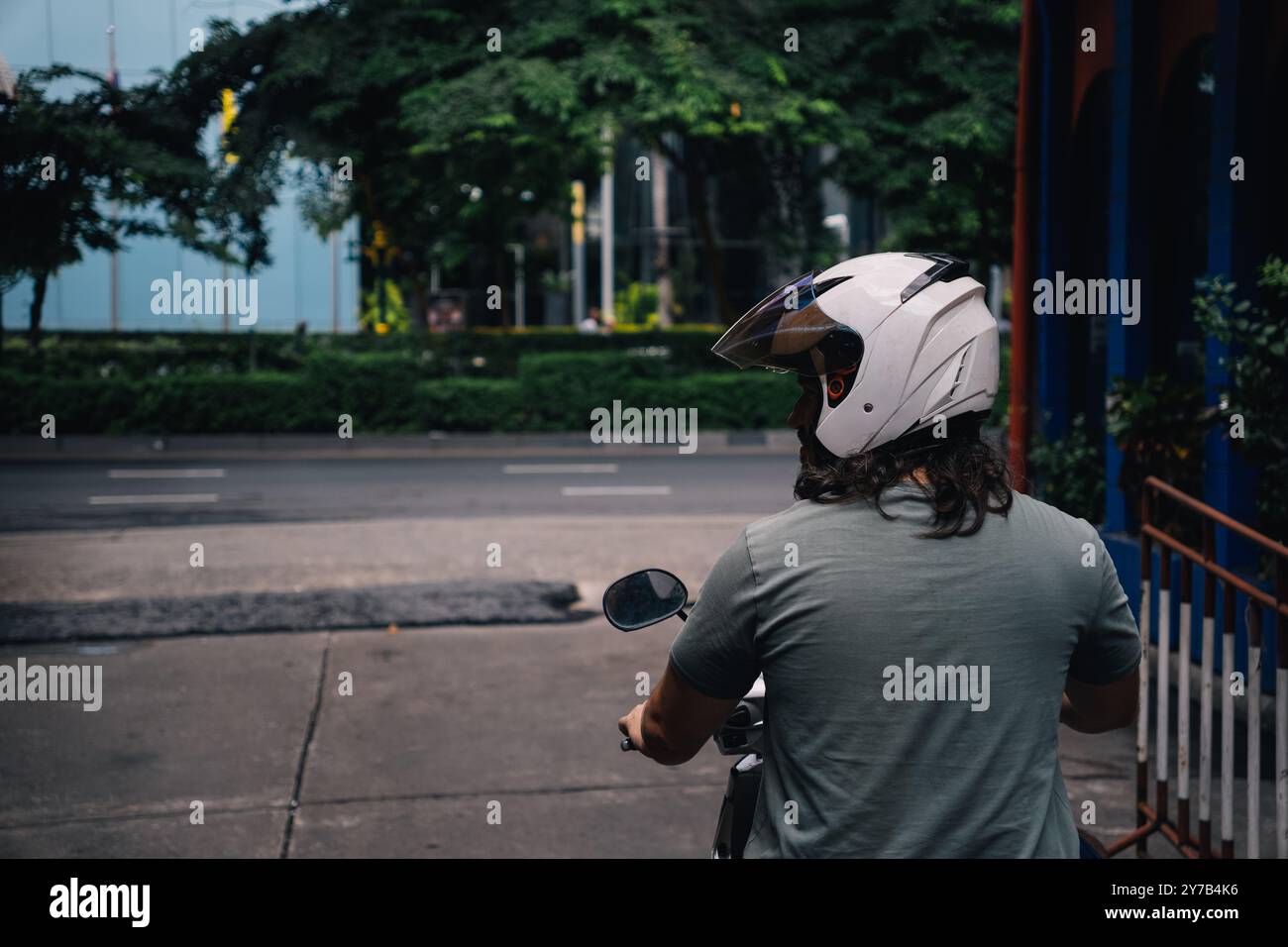 Horizontal back view of mid adult man driving a motorbike with an open ...