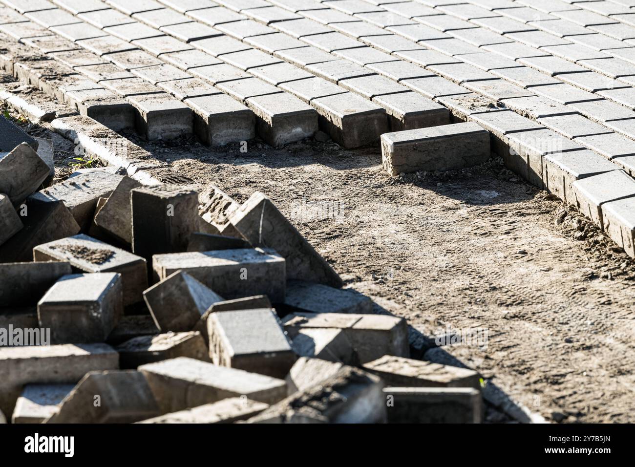 dismantling old paving stone tiles on the street, close-up. repair of ...