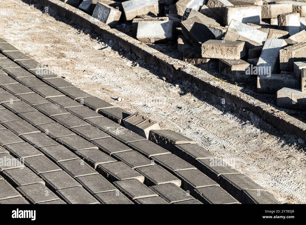 dismantling old paving stone tiles on the street, close-up. repair of ...
