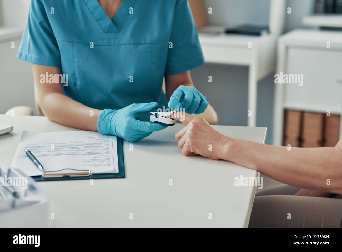 Close up of female nurse using monitoring equipment to check pulse ...