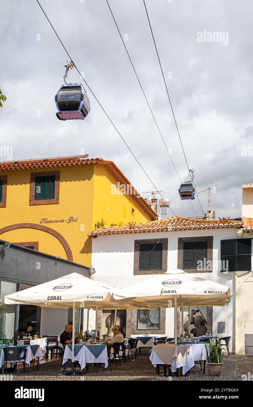 Cable car passing over bars and restaurants in Funchal the capital of ...