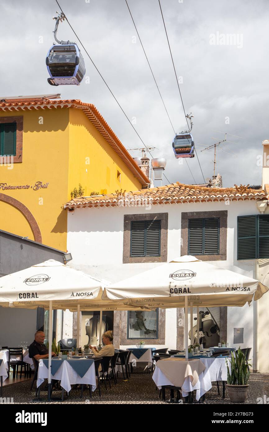 Cable car passing over bars and restaurants in Funchal the capital of ...