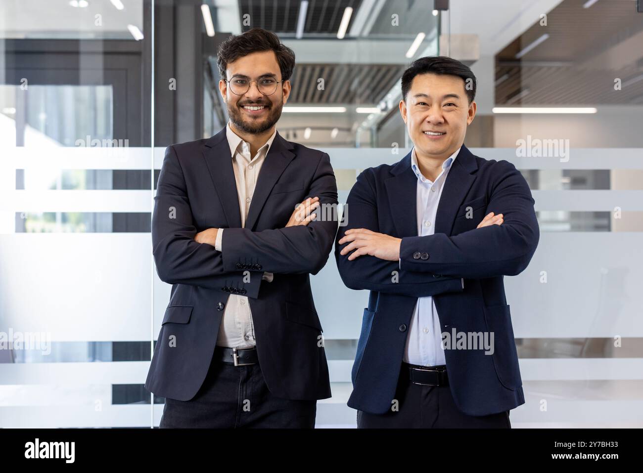 Two professional businessmen standing with arms crossed in modern ...