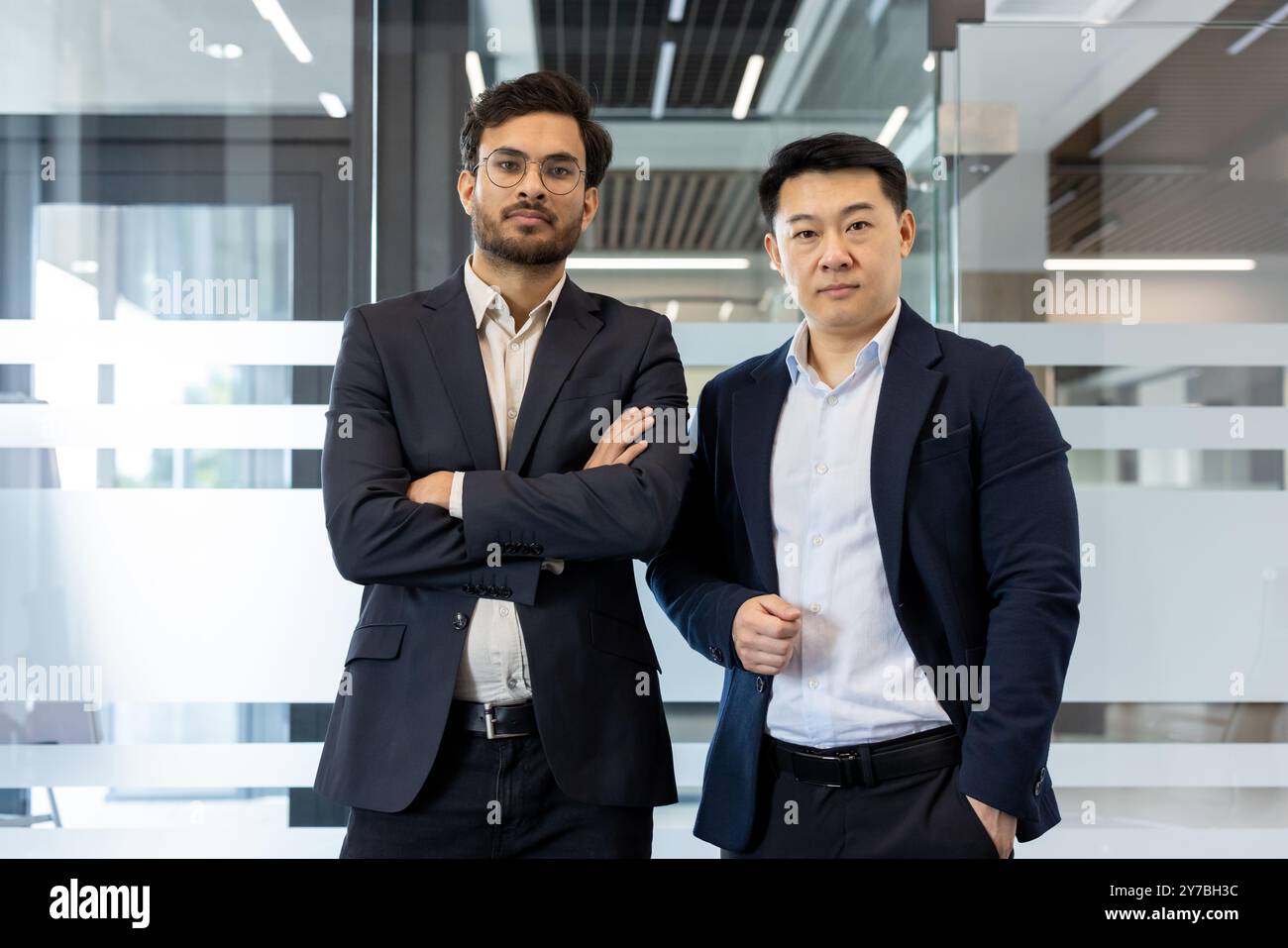 Confident professionals standing in office setting, displaying teamwork ...