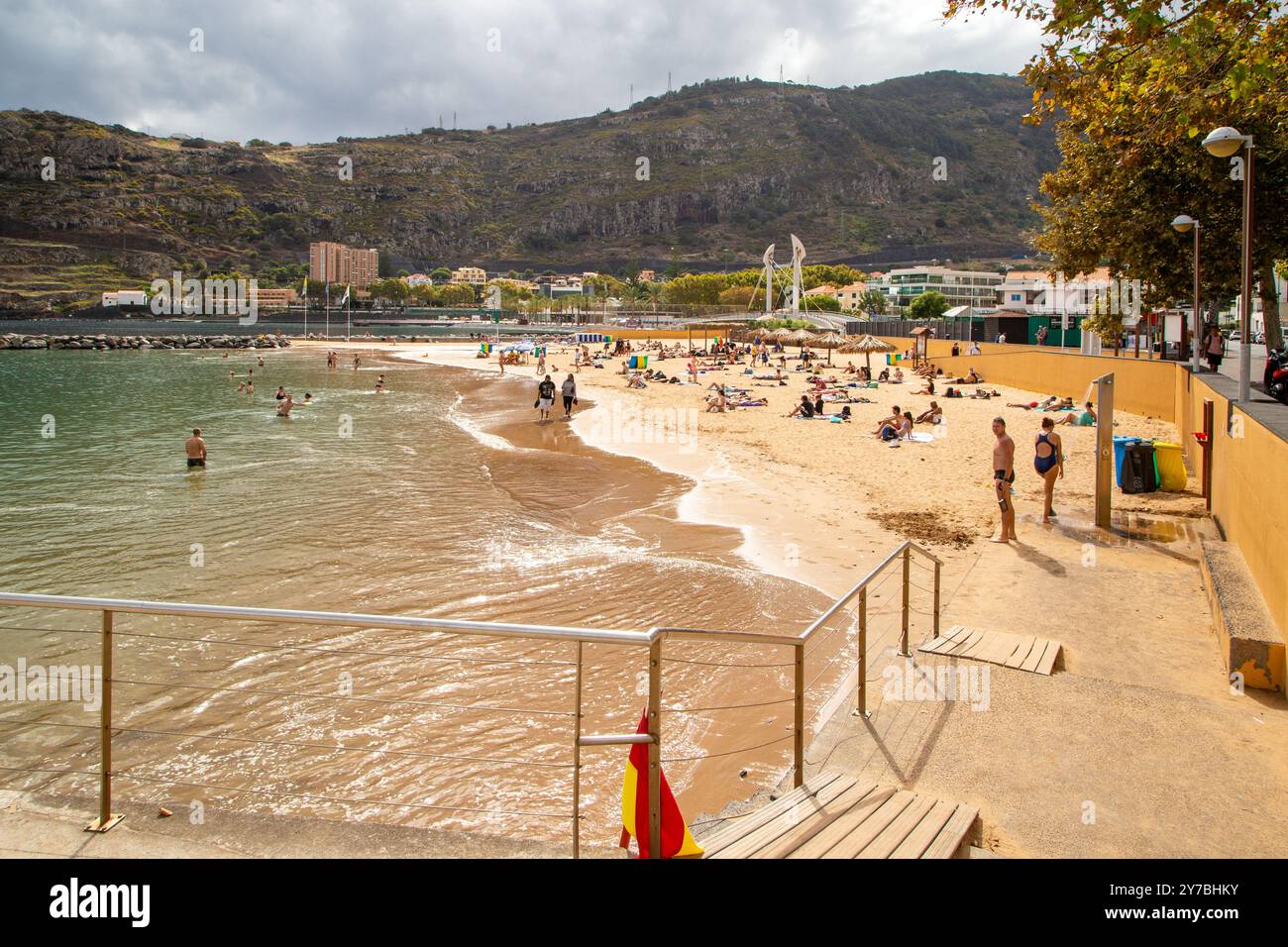 Holidaymakers sunbathing on the artificial beach of imported sand from ...