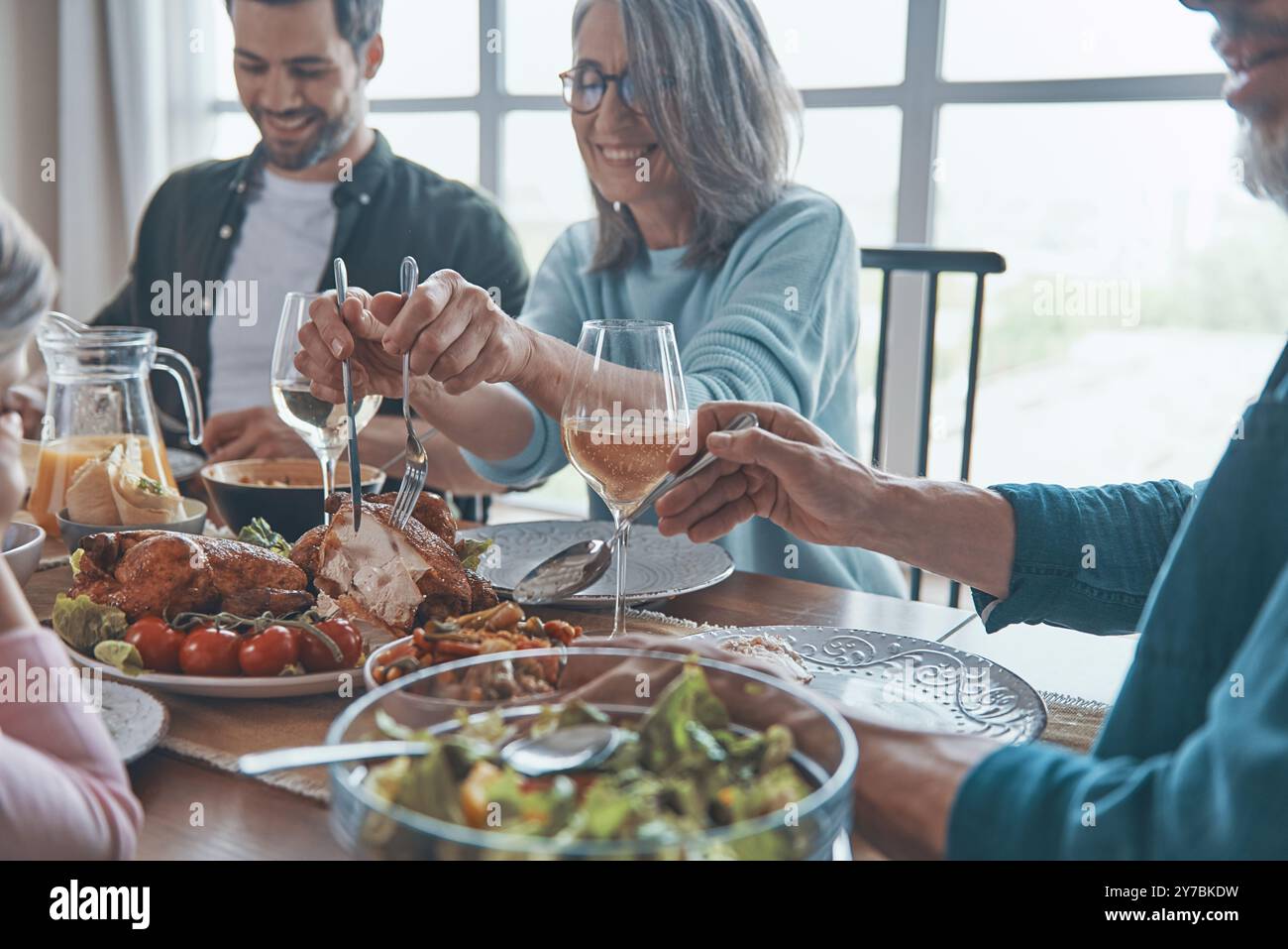 Happy multi-generation family holding hands and praying before having ...