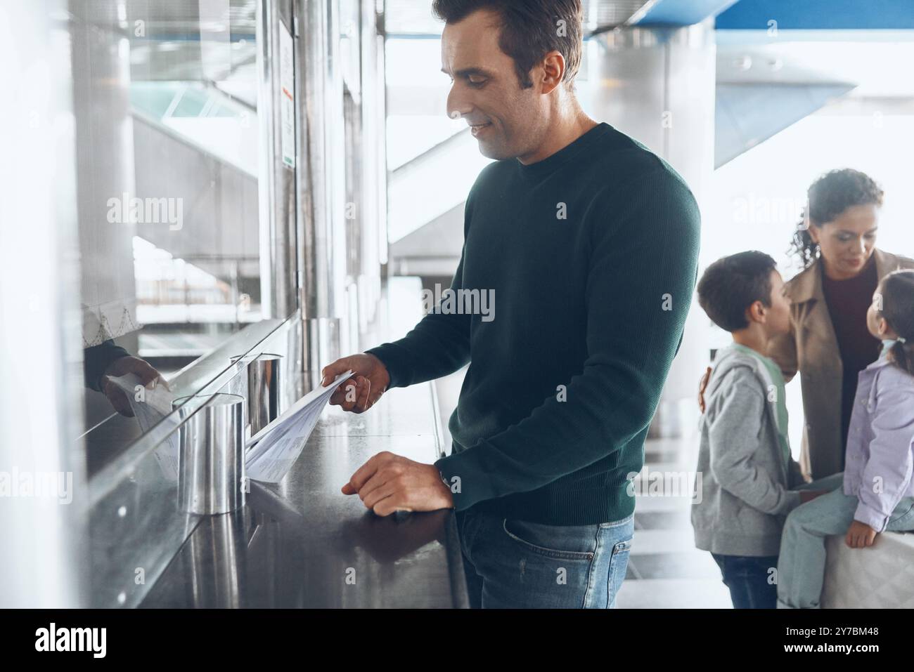Family with two little kids buying tickets at ticket counter Stock ...