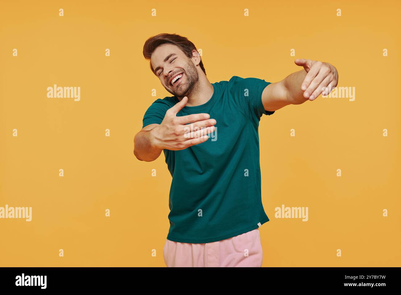 Happy young smiling man in casual clothing looking at camera and ...