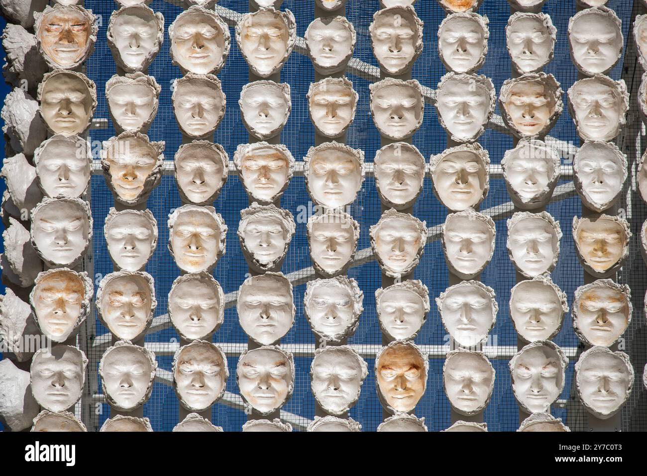 Plaster casts faces placed in lines at the installation on the ...