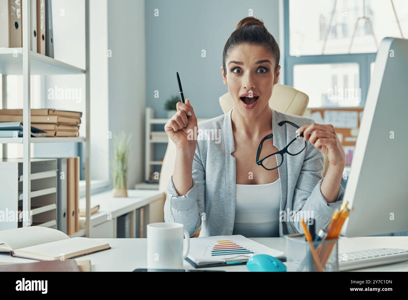 Beautiful young woman in smart casual wear making a face while working ...