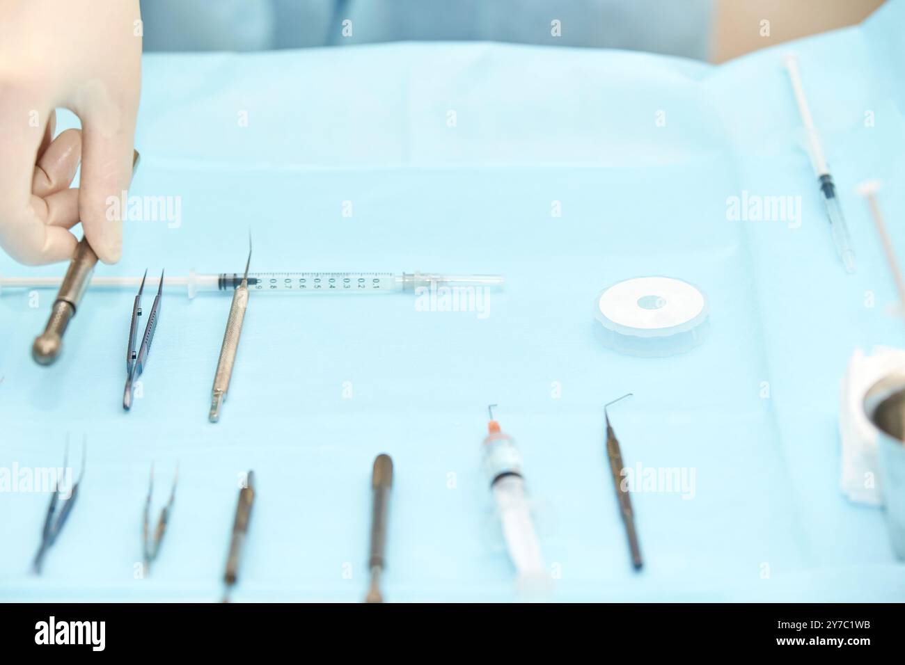 Sterile medical instruments and syringe on surgical tray in hospital ...
