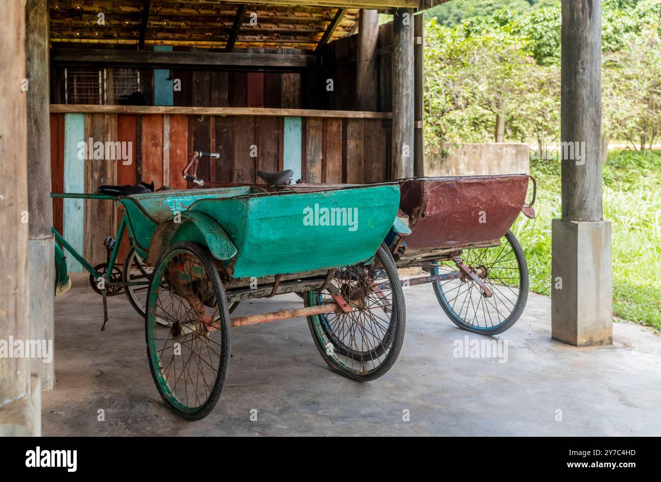 Old cycle rickshaws parked under a house in Kampot in Cambodia Stock ...