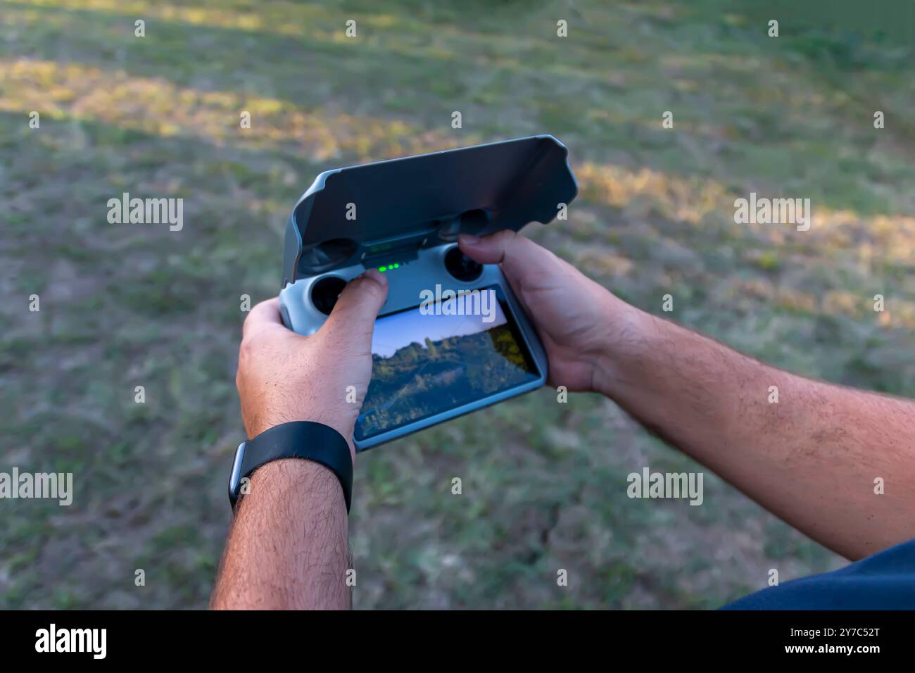 A man a drone pilot with a control panel in his hands controls a ...