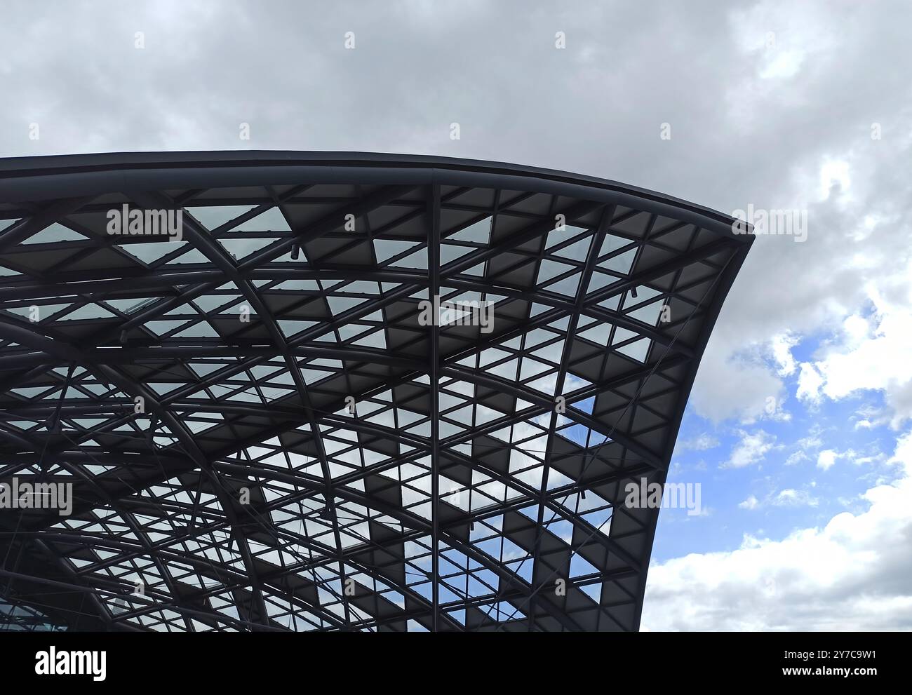 A striking architectural detail showcasing a modern glass and steel ceiling structure. The ...