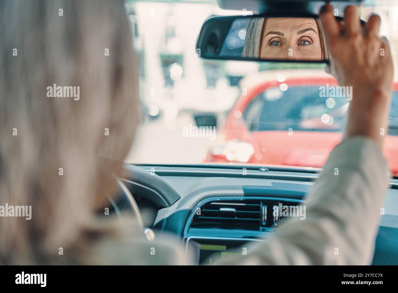 Rear view of mature beautiful woman in smart casual wear adjusting back ...