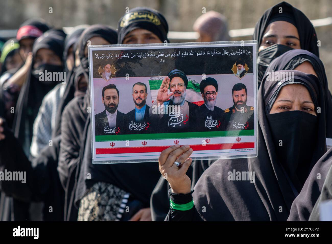 Kashmiri Muslim woman holds a portrait of Iranian officials as they ...