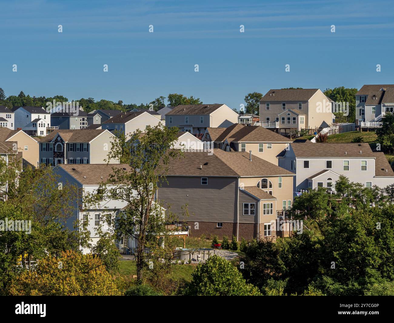 Single-family homes sit nestled in a typical American suburb ...