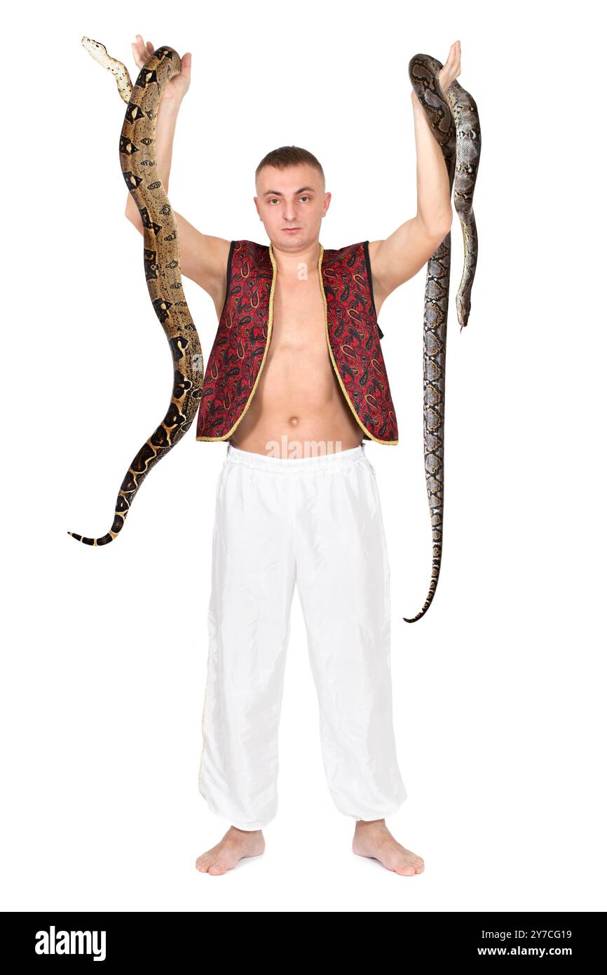 Young Caucasian man in Eastern costume interacting with snakes Stock ...