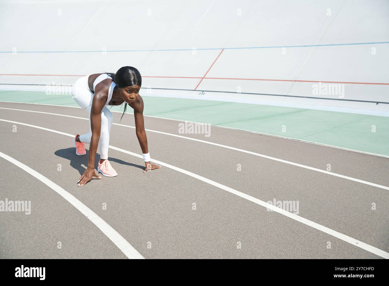 Beautiful young African woman standing at starting position on running ...