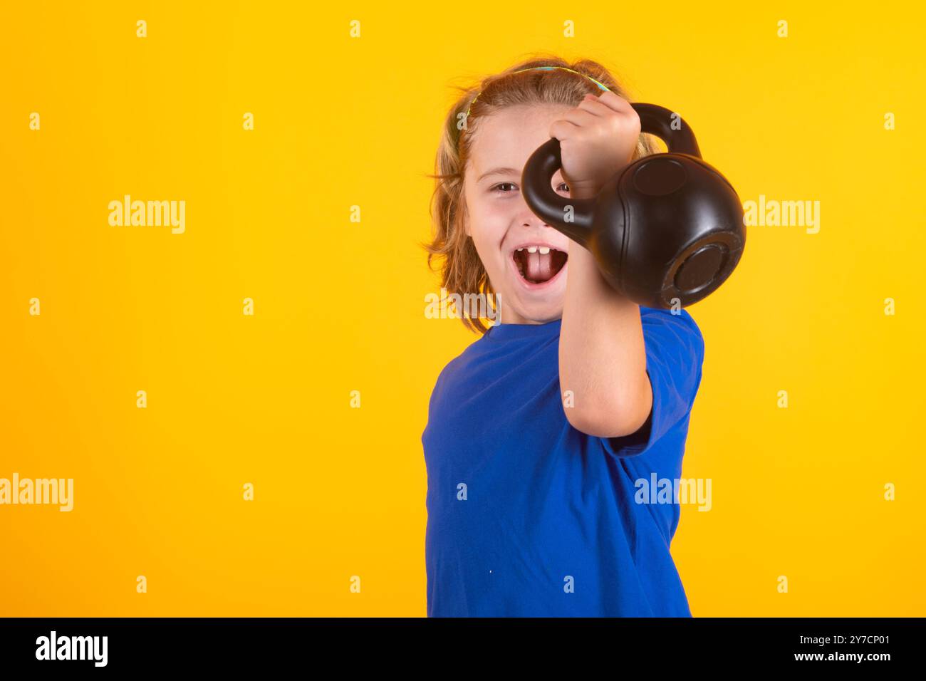 Sport activities at leisure with children. Blonde boy holding kettlebell. Sports exercises for ...