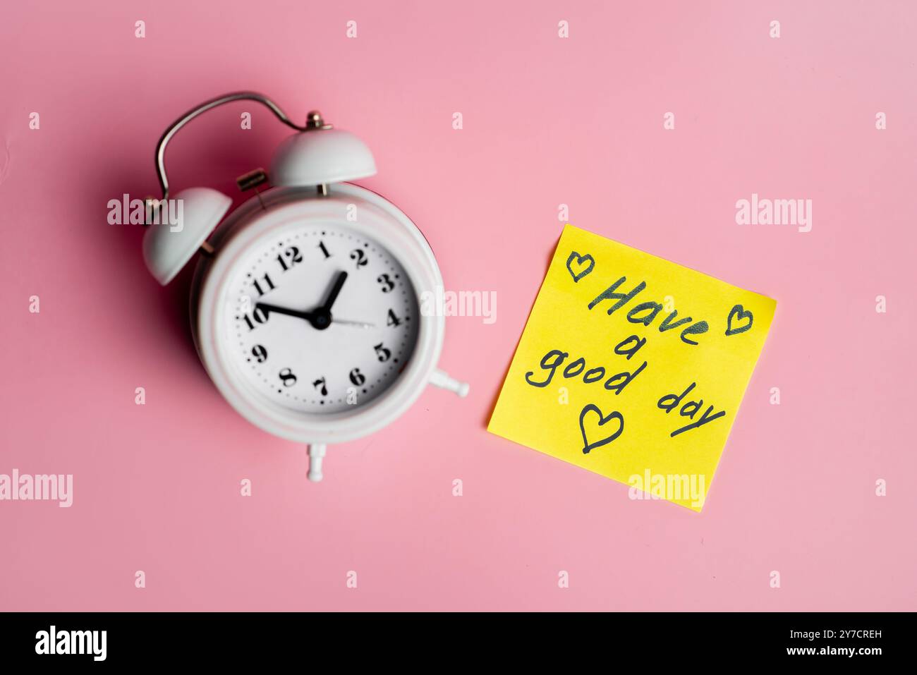 Retro white alarm clock and positive message on pink background for a ...